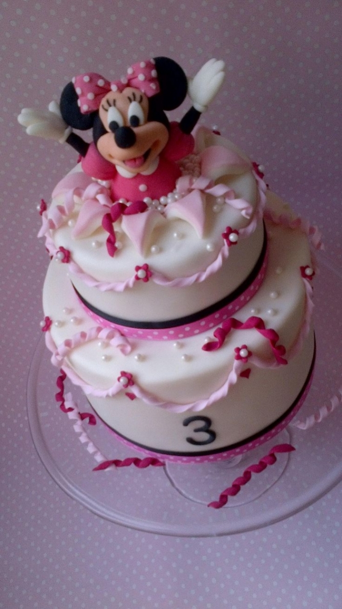 gâteau avec minnie et un décors rose et rouge avec des perles blanches ...