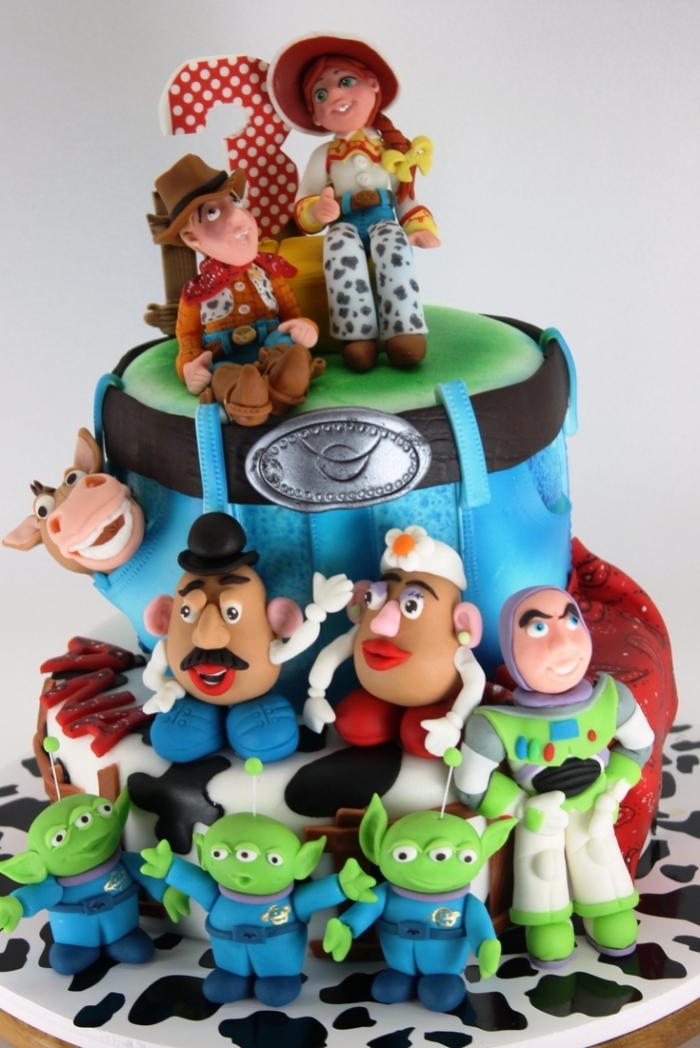 gâteau avec plusieurs personnages disney avec un décor bleu et vert ...